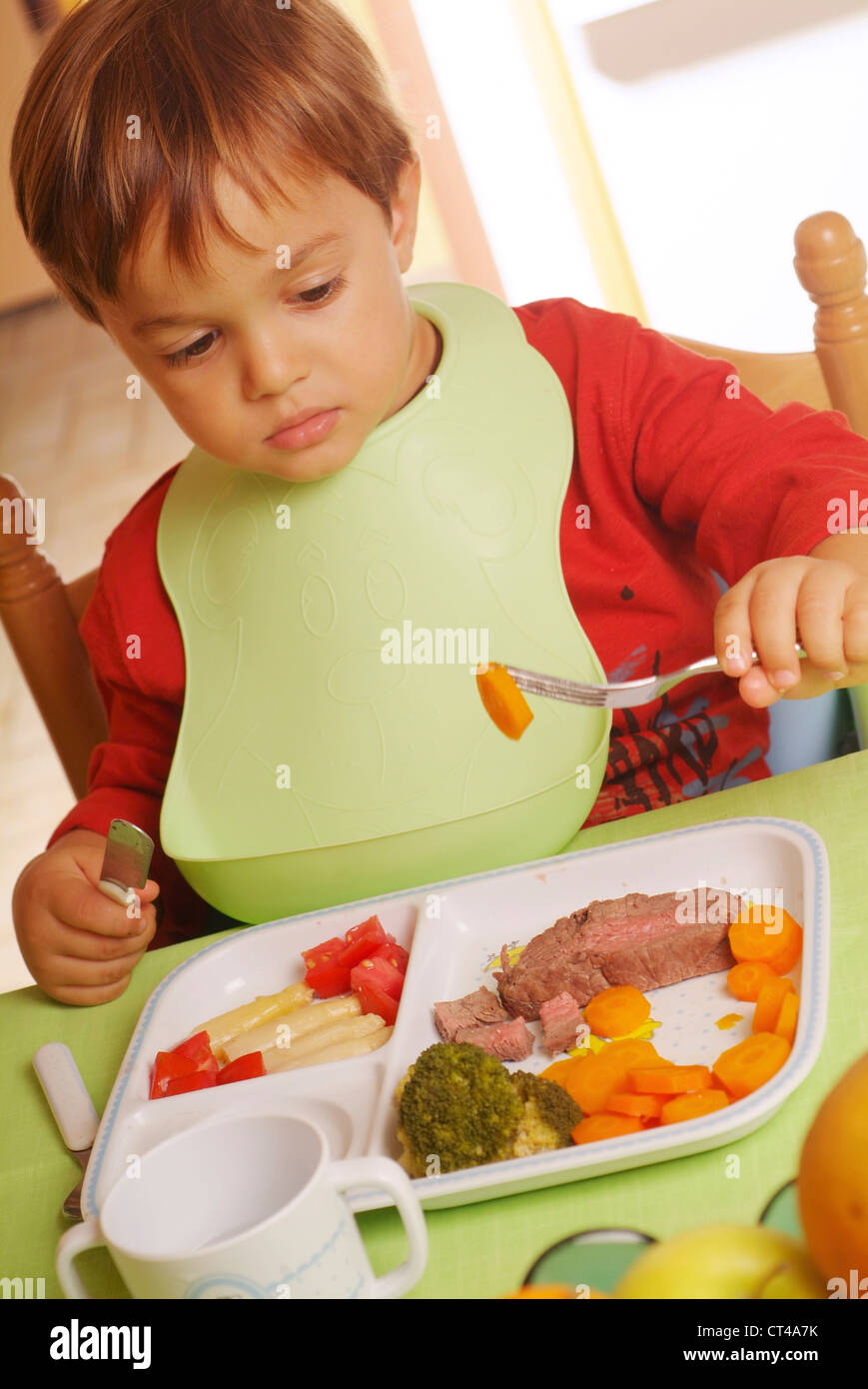 CHILD EATING MEAT Stock Photo - Alamy