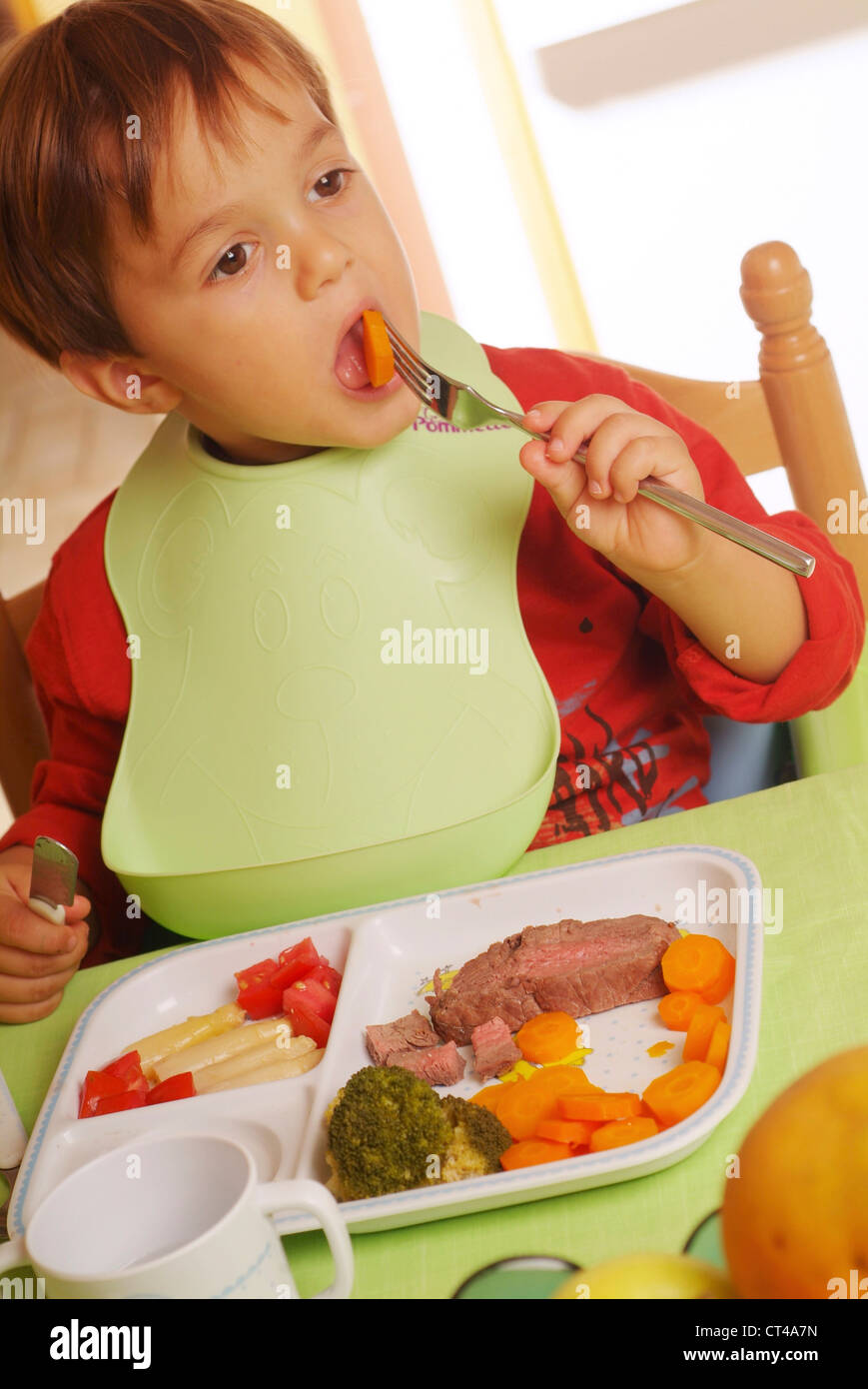 CHILD EATING MEAT Stock Photo - Alamy