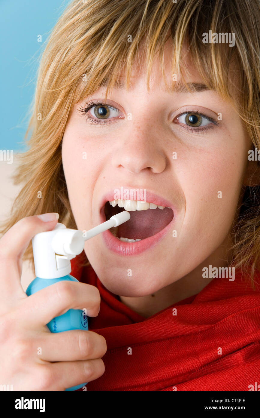 WOMAN USING SPRAY IN MOUTH Stock Photo - Alamy