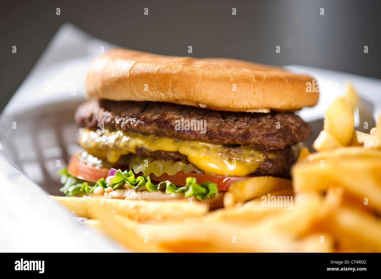 A cheeseburger in a basket with french fries Stock Photo - Alamy