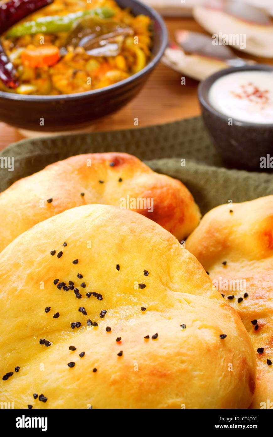 Freshly baked Indian naan bread, with butter and onion seeds, dal and ...