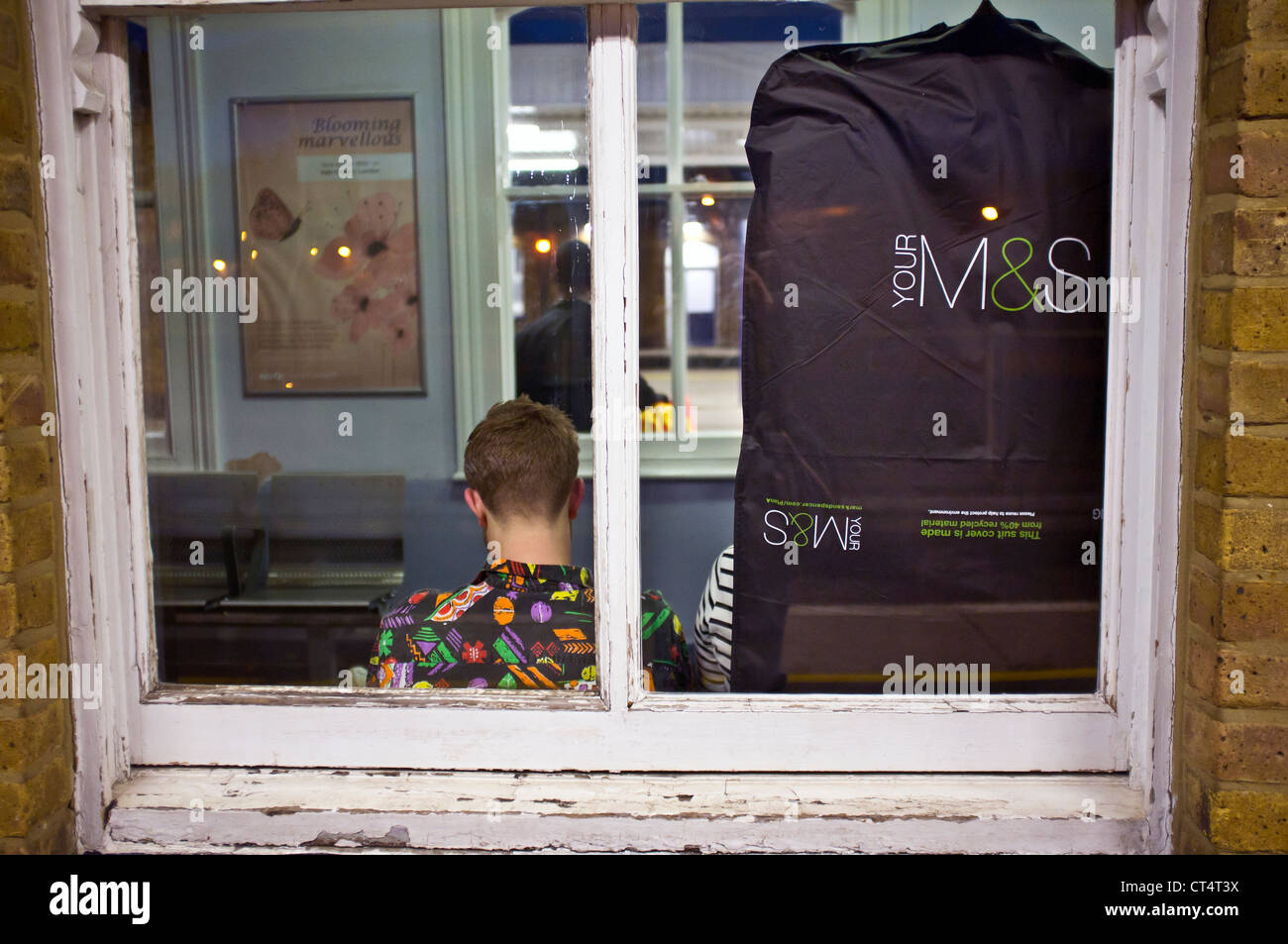 Couple in train waiting room with M&S suit carrier hanging up Stock ...
