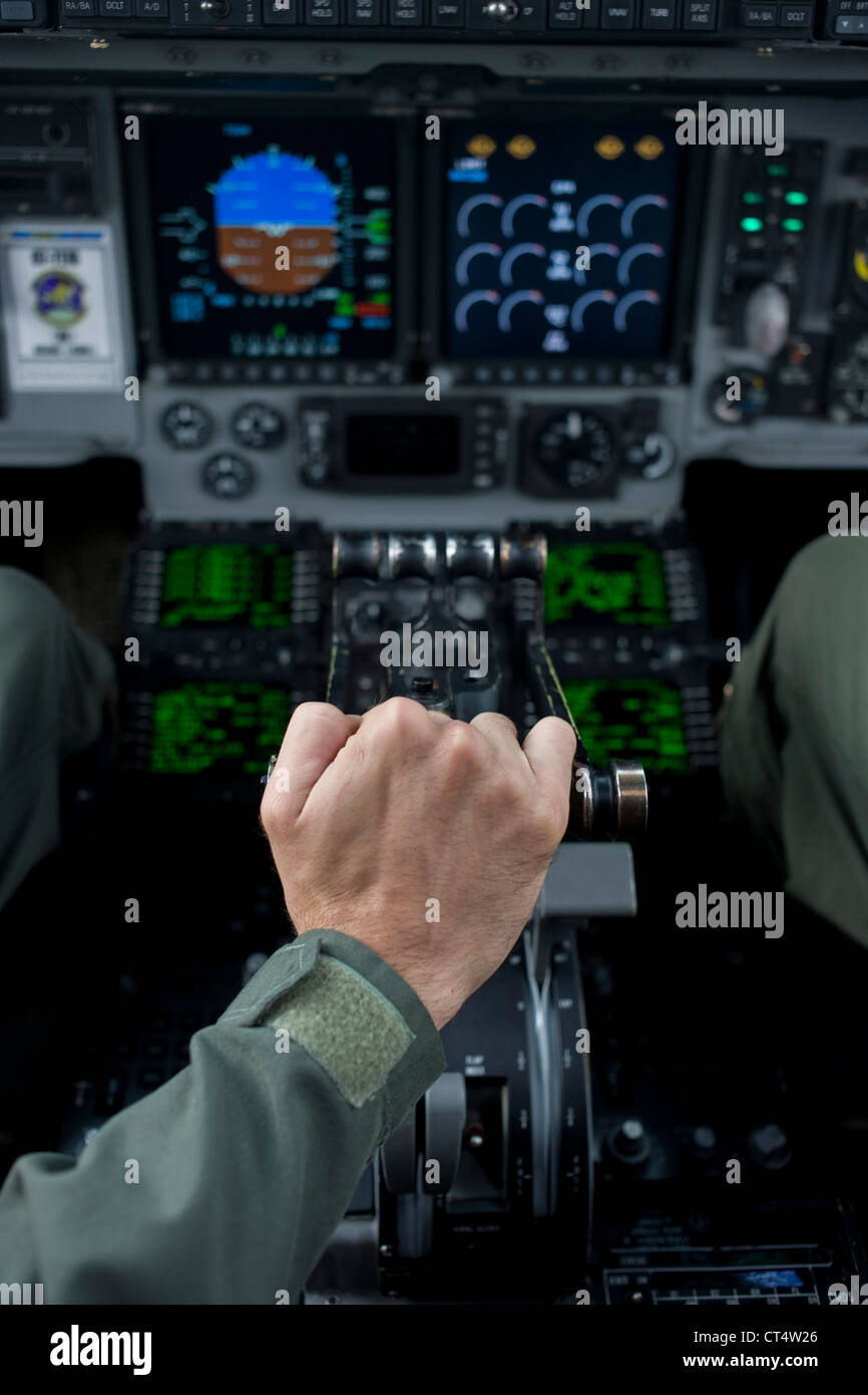 A pilot of the US Air Force holds the throttle levers in the cockpit of ...