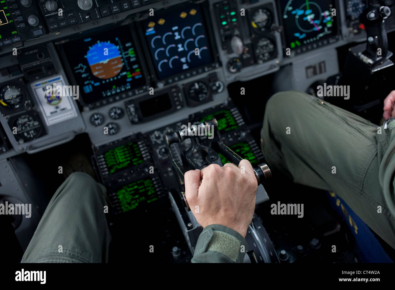 A pilot of the US Air Force holds the throttle levers in the cockpit of ...