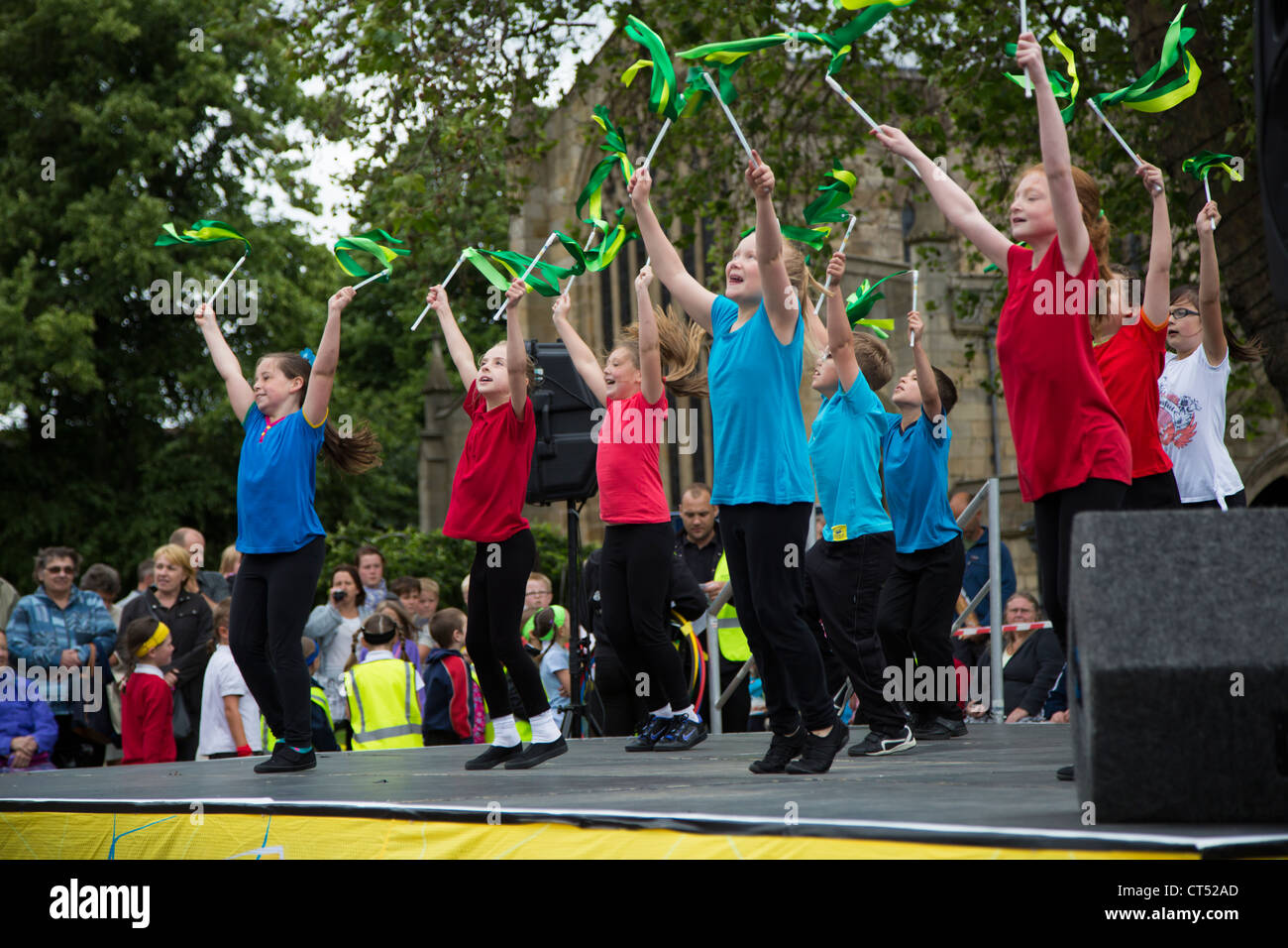 Young children dancing and celebrating the Olympic Torch relay passing ...