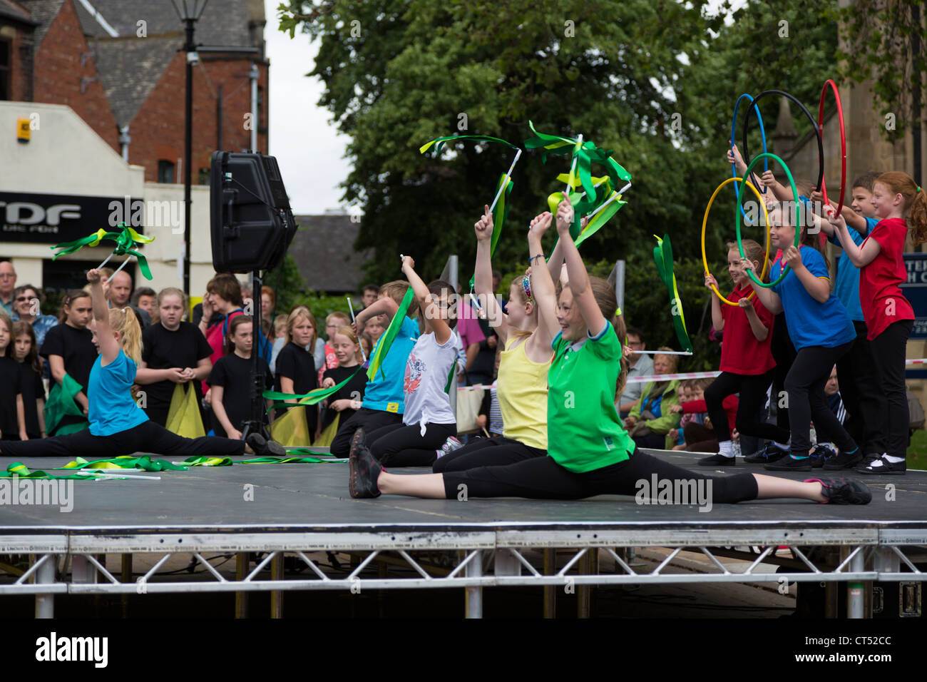 Young children dancing and celebrating the Olympic Torch relay passing ...