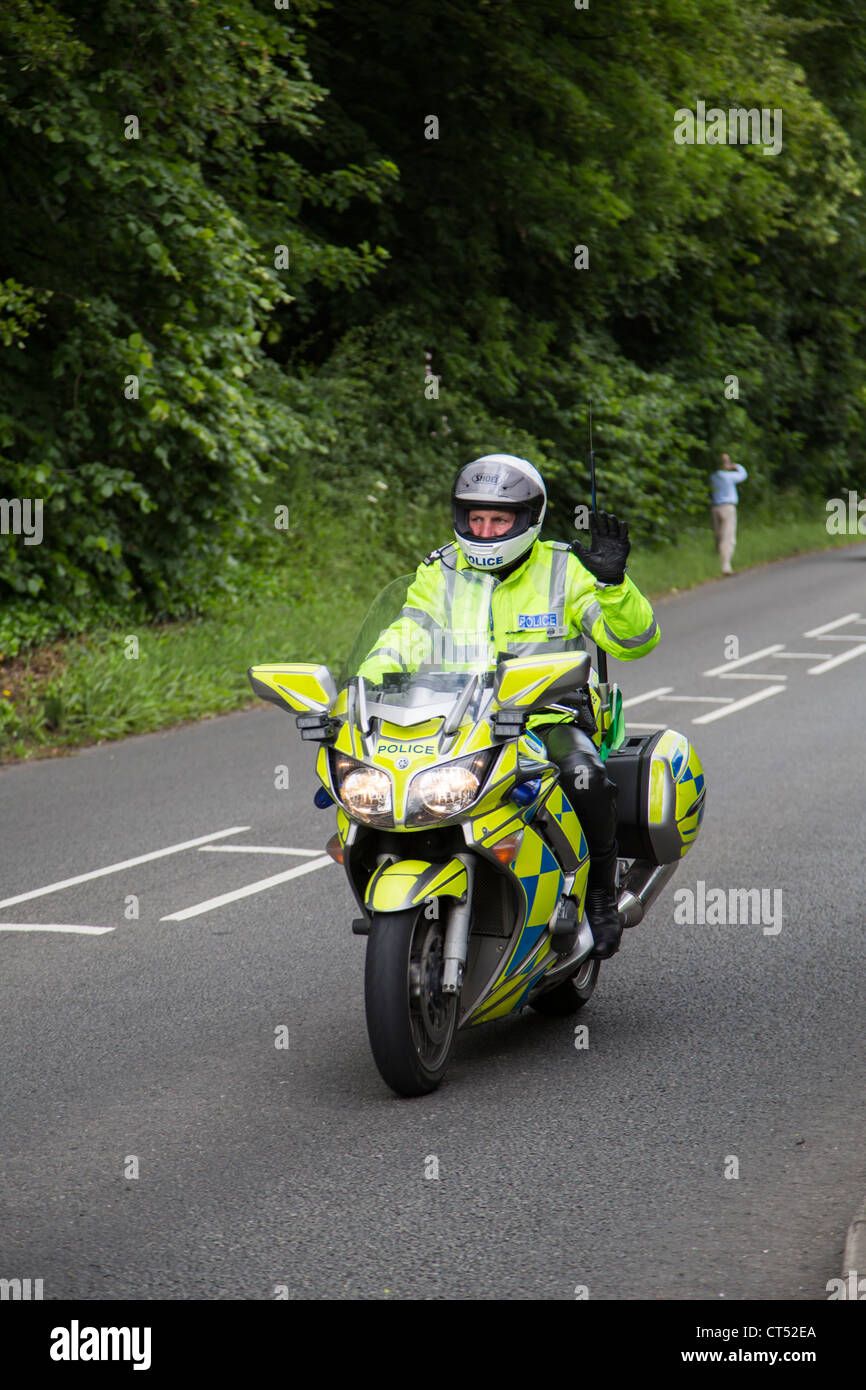 Police motorcycle rider waving at the crowds during the Olympic torch ...