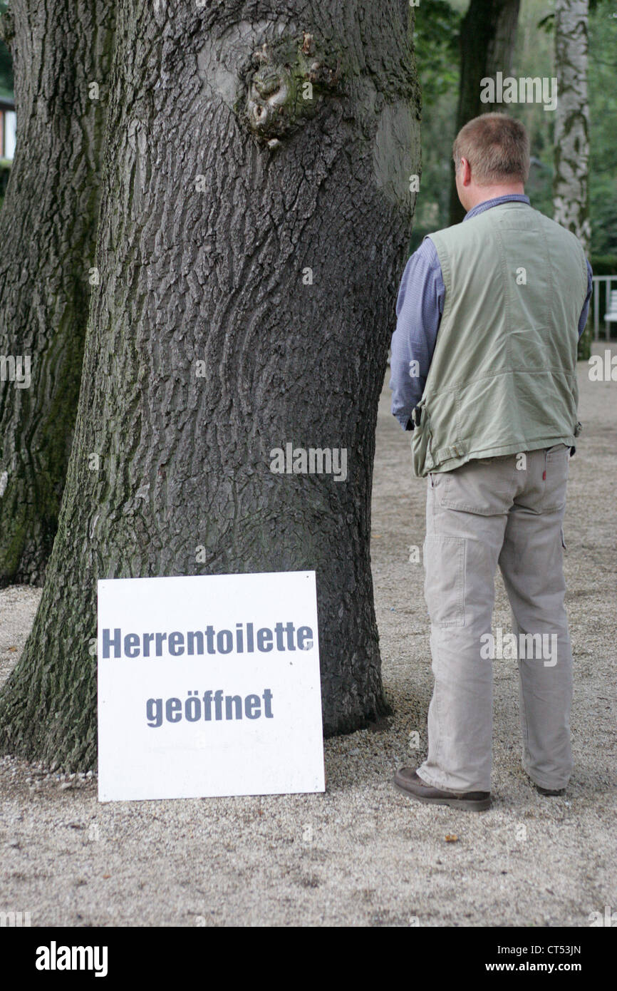 Men's room opened, a man urinating while standing against a tree Stock ...