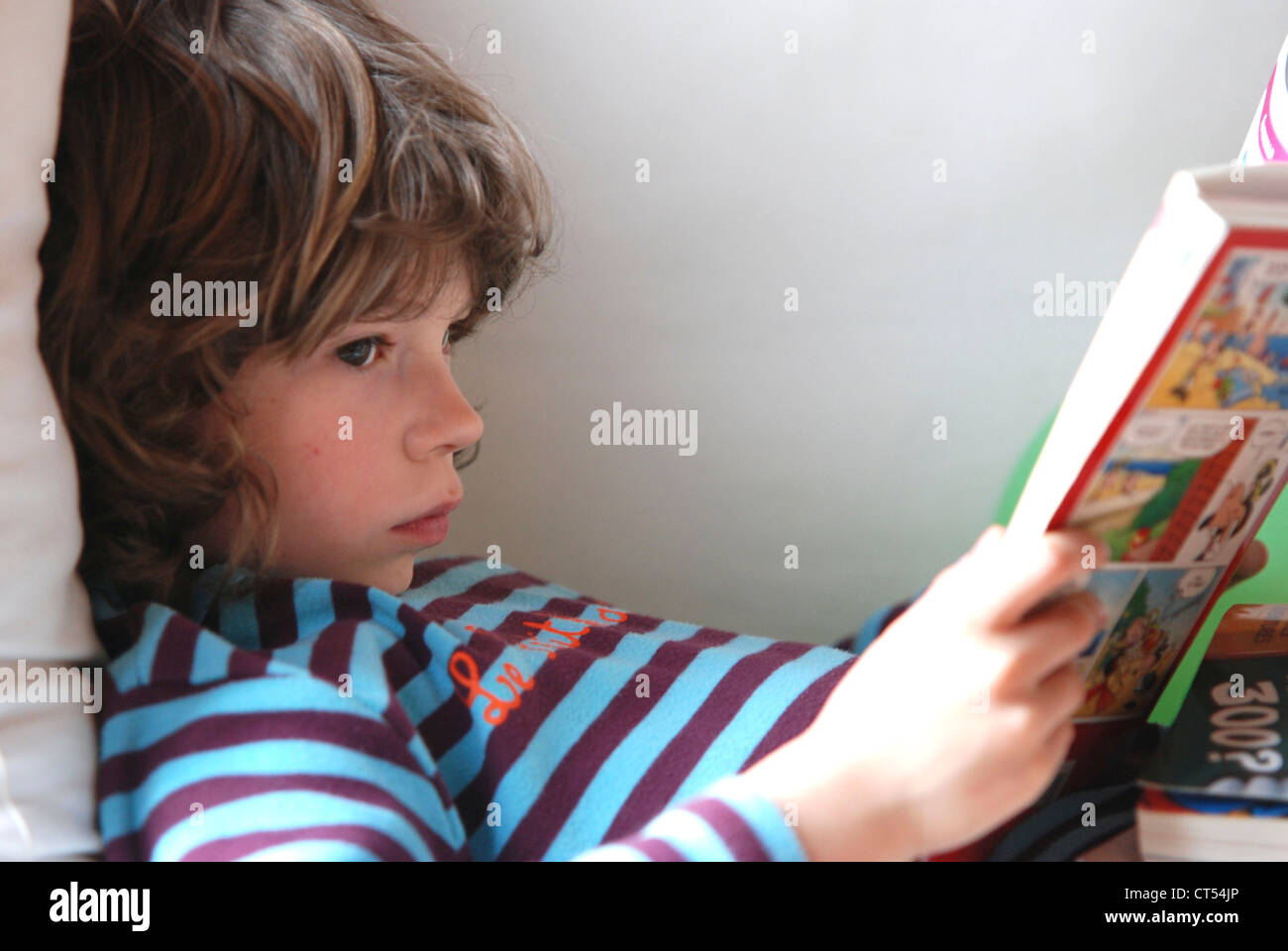 CHILD READING INDOORS Stock Photo - Alamy