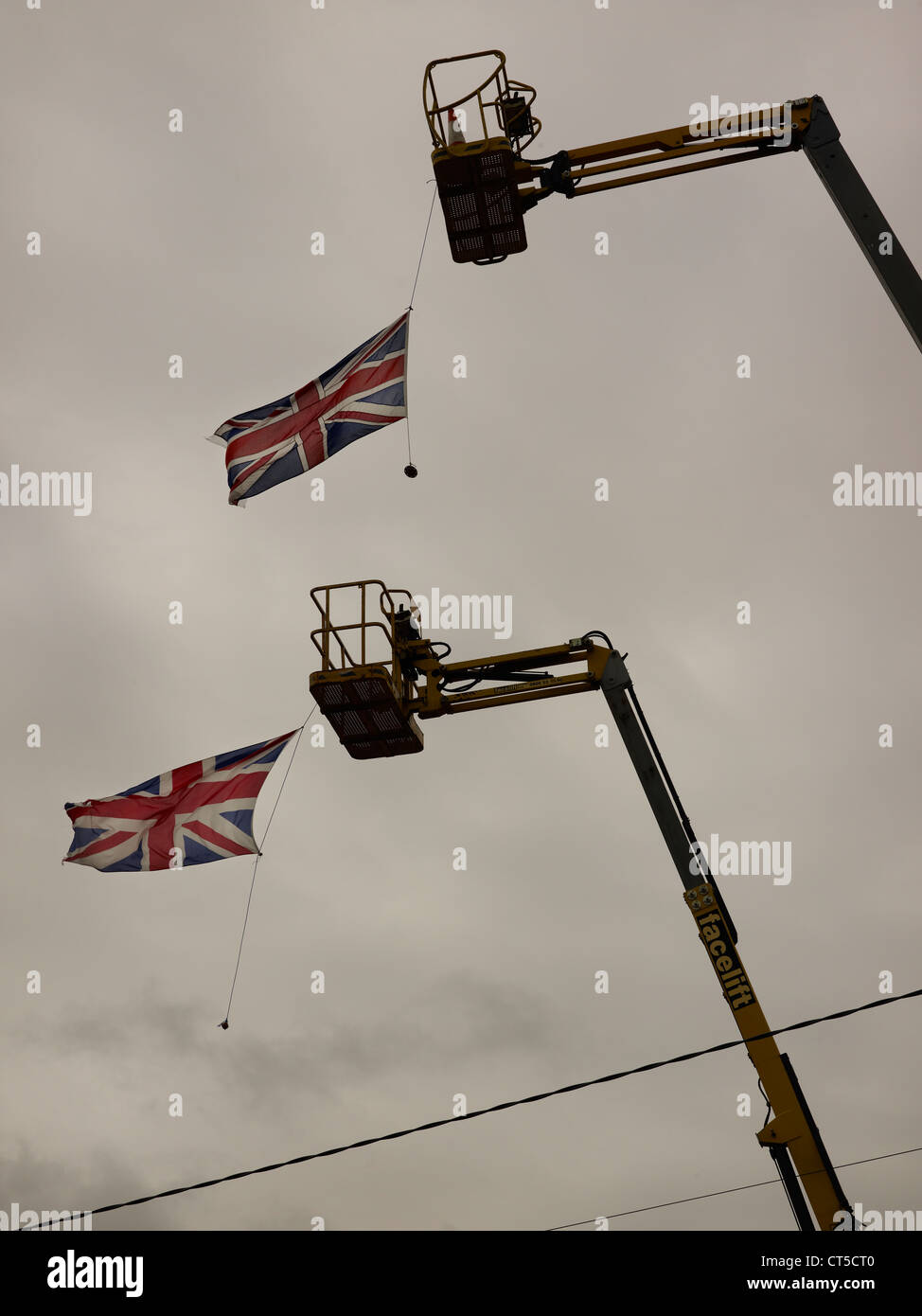 Two crane lift or access platforms with Union flags flying from them ...
