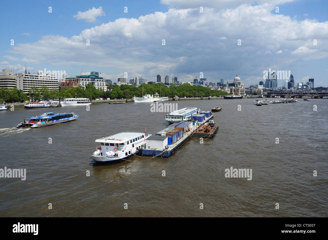 Cruise boats and pontoon moorings with city skyline, River Thames ...