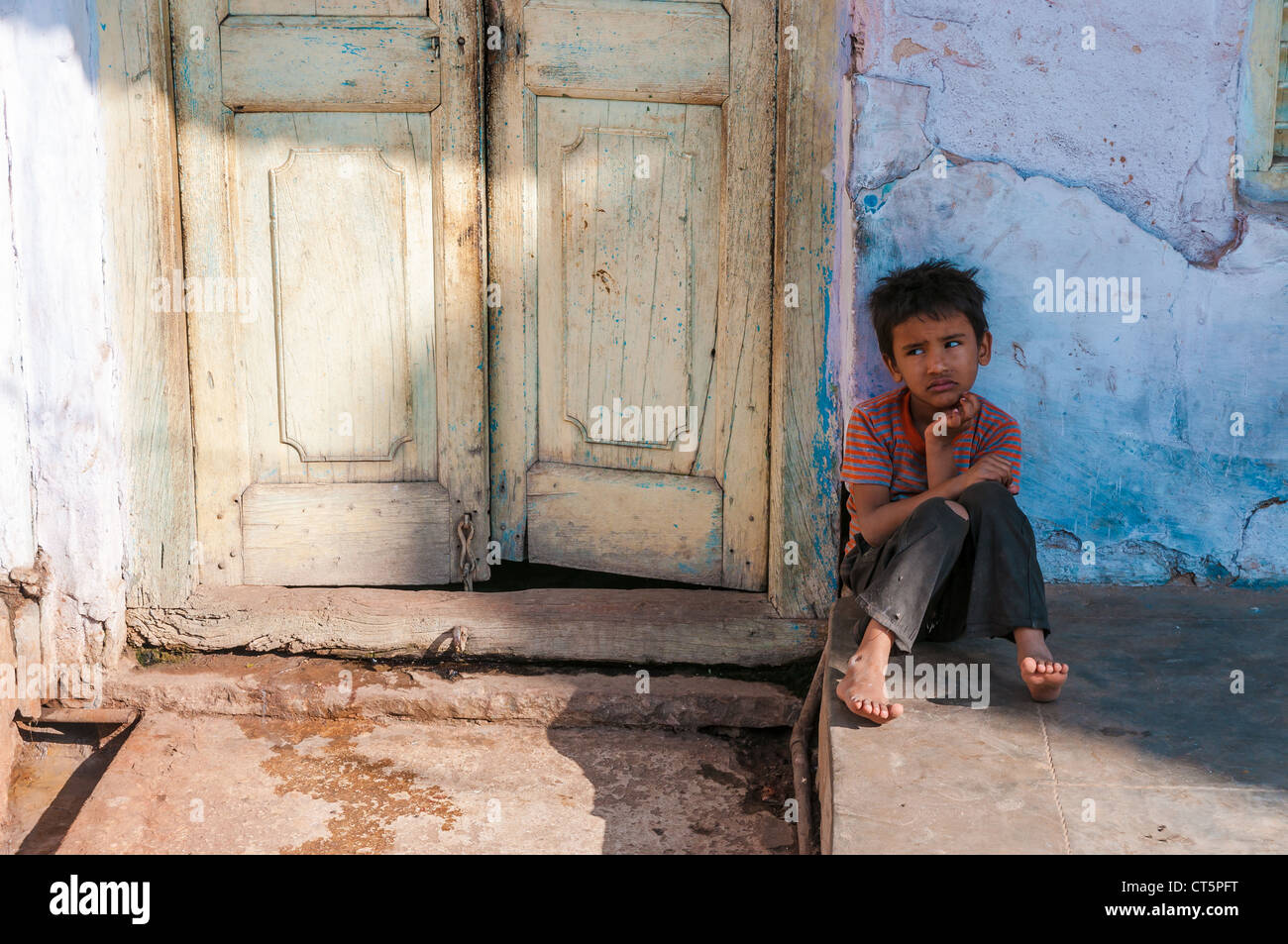 Poor boy sitting in front of a doorway, Pushkar, Rajasthan, India Stock ...