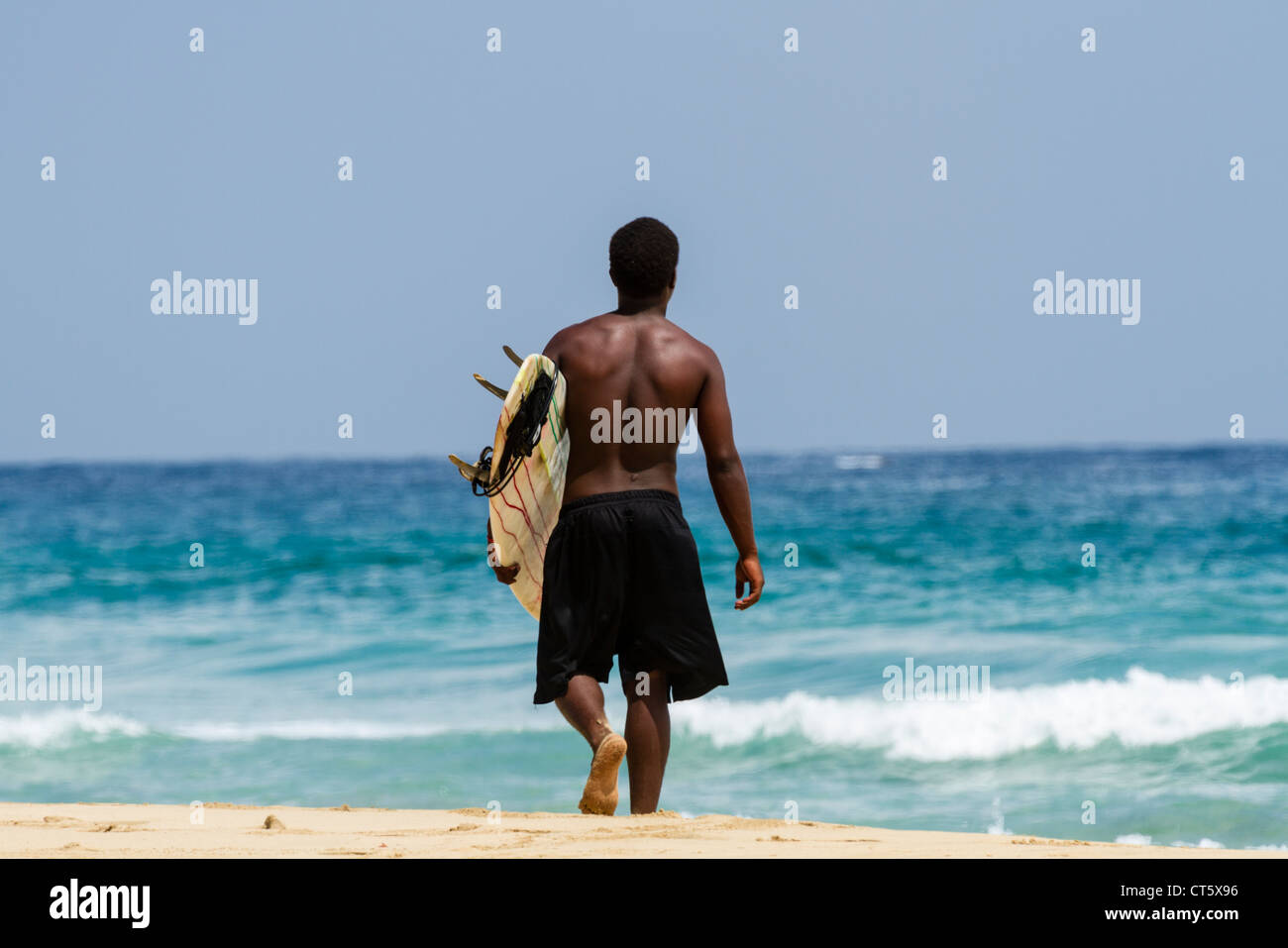 Surfer carrying board at Wizard Beach (First Beach) on Isla Bastimentos ...