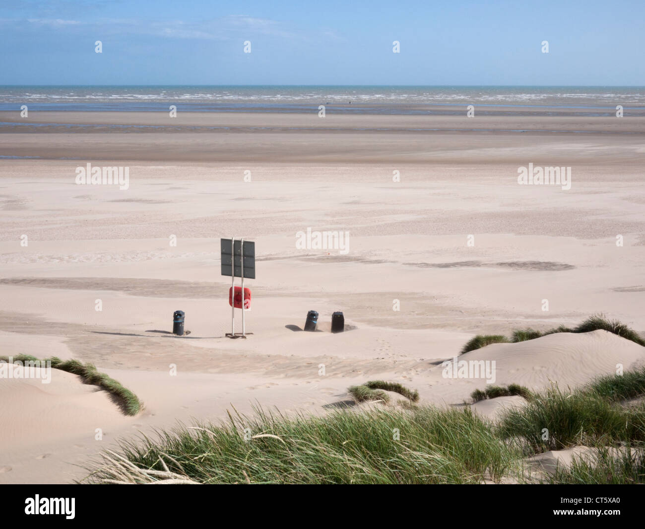 a view of Camber Sands and sea on a windy day with sand blowing across ...