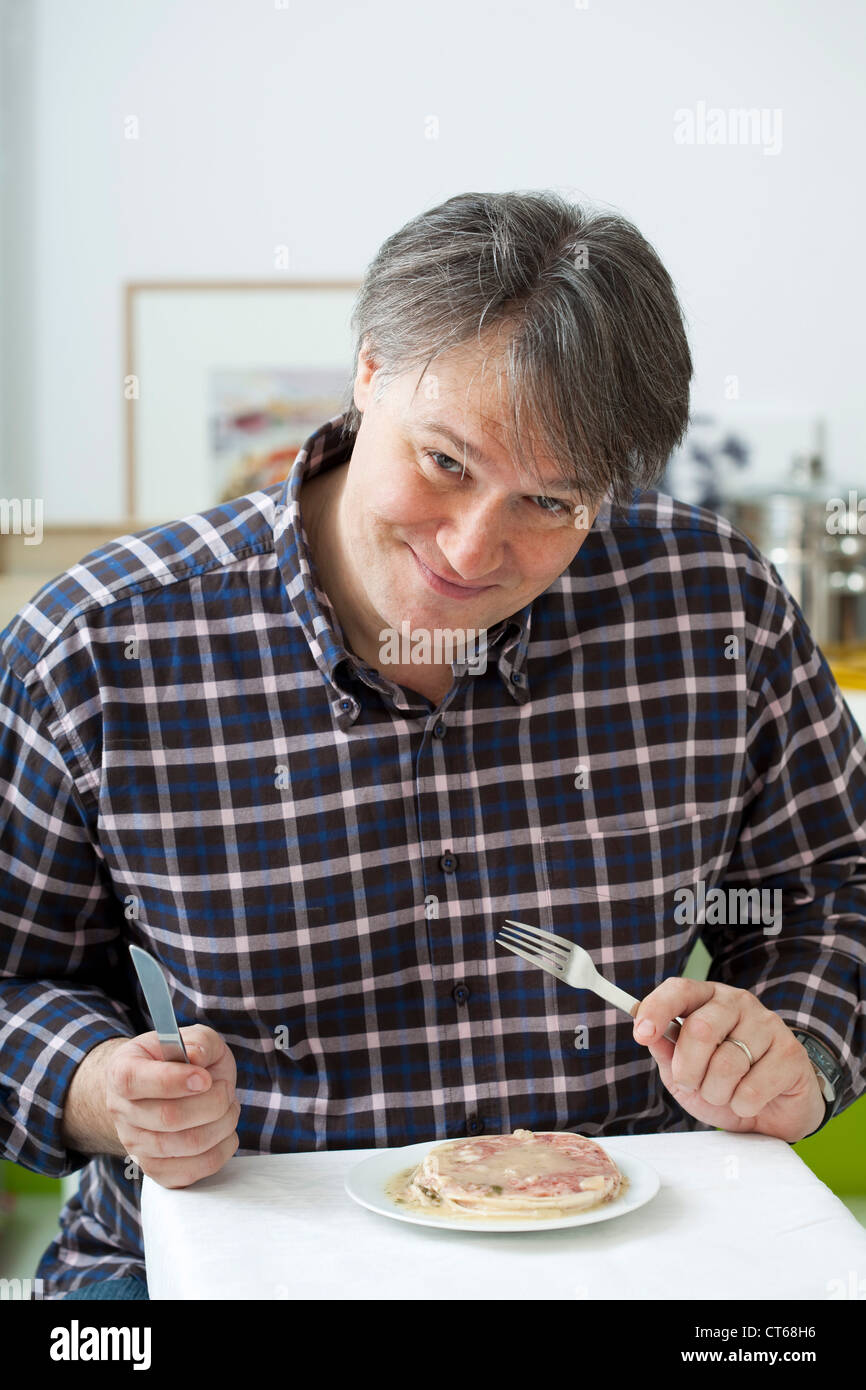 MAN EATING PORK MEAT Stock Photo - Alamy