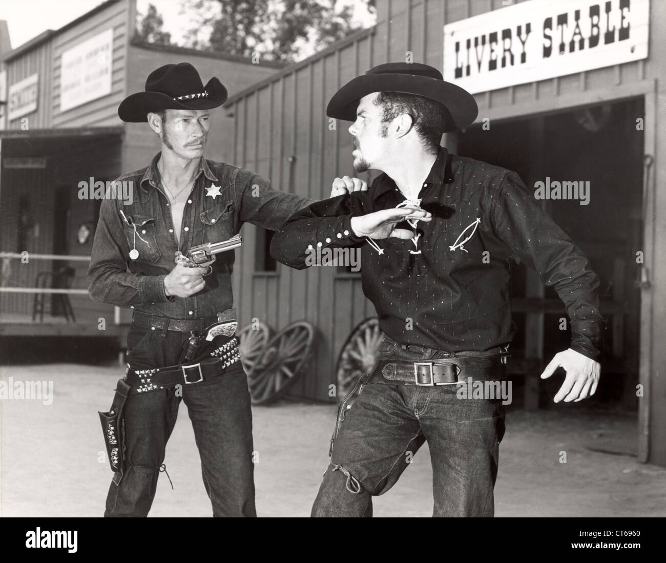 Sheriff with gun stopping cowboy Stock Photo - Alamy