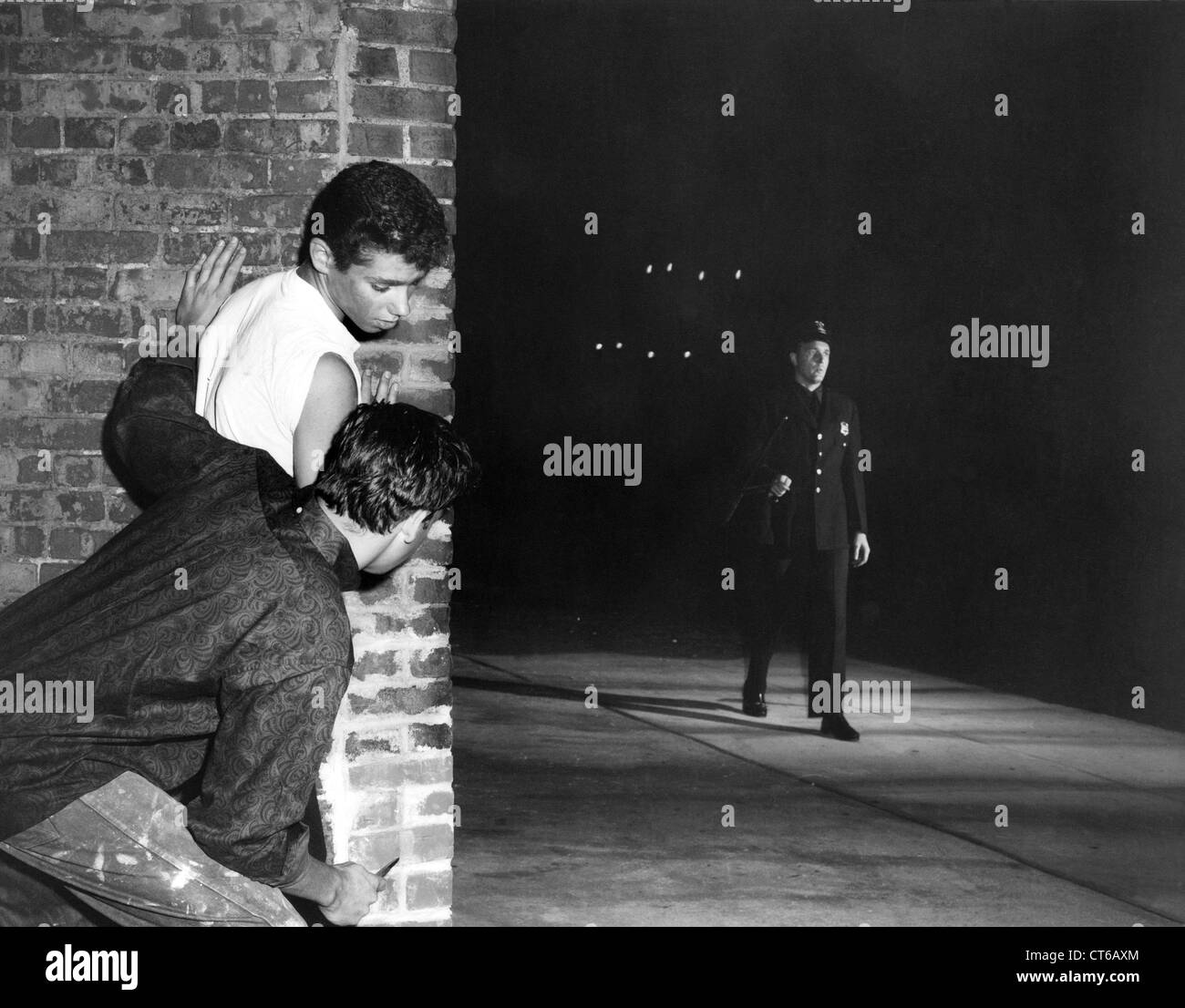 Teenage boys hiding from policeman Stock Photo - Alamy