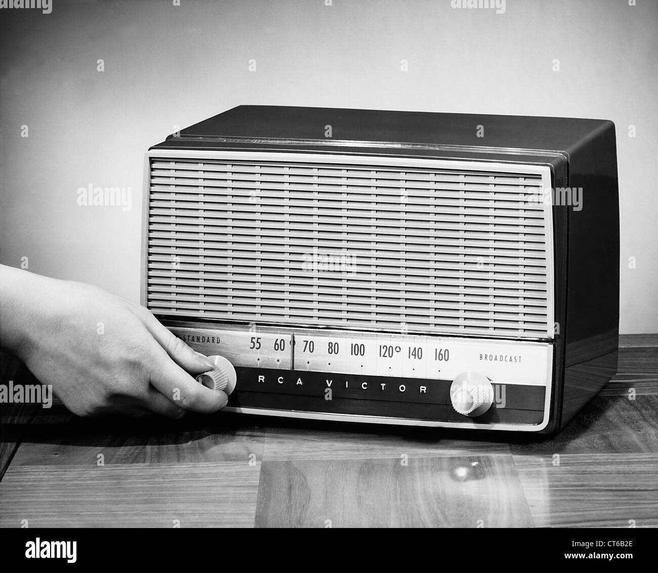 Woman turning on radio Stock Photo - Alamy