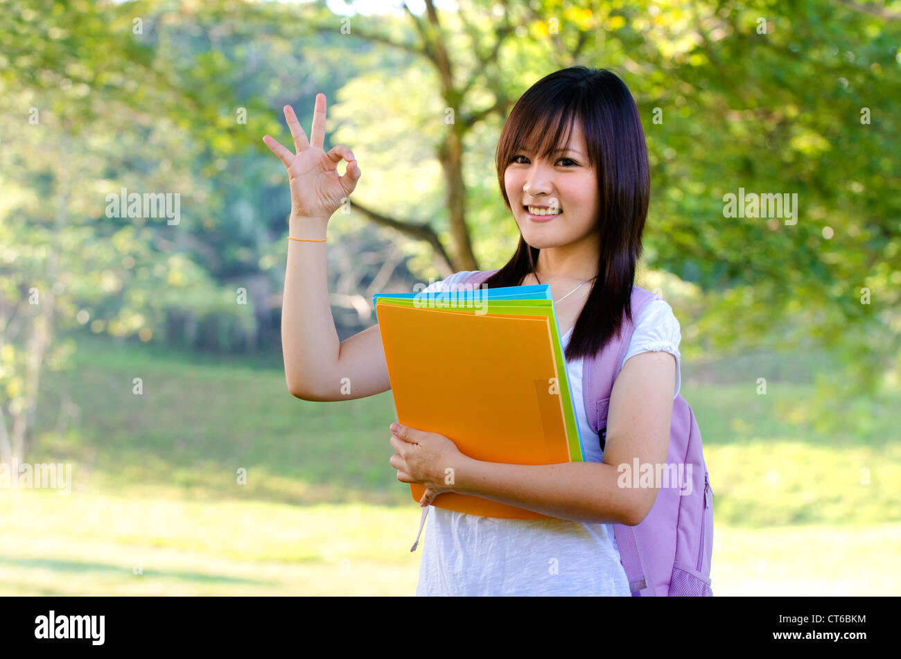 Mixed race ok sign college girl standing at campus Stock Photo - Alamy