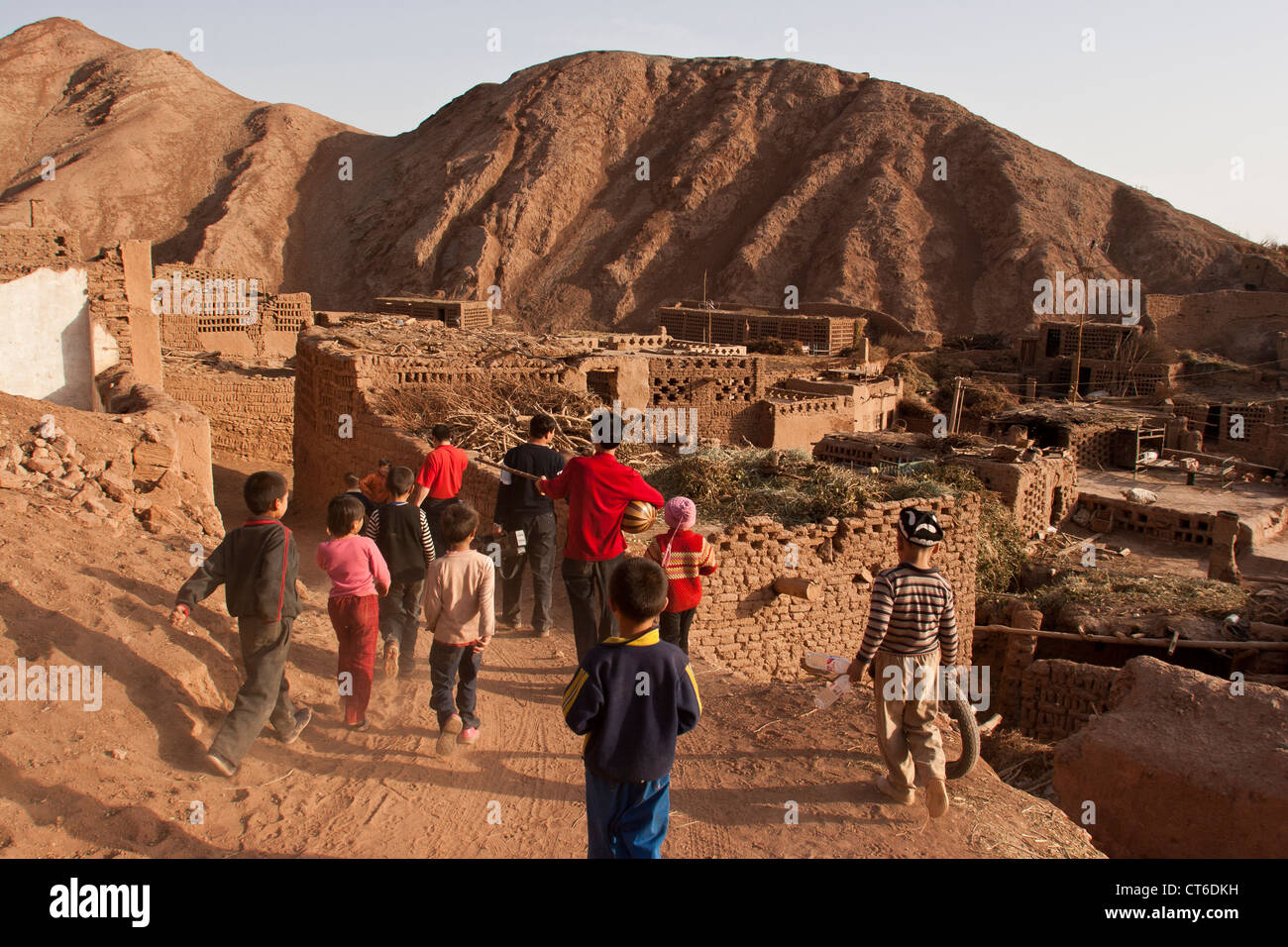 Villagers with musical instruments walk through Maza village near ...
