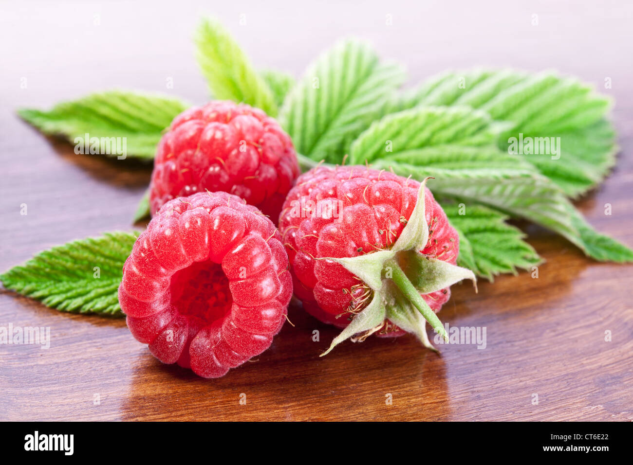 Ripe raspberries isolated on a wooden background Stock Photo - Alamy