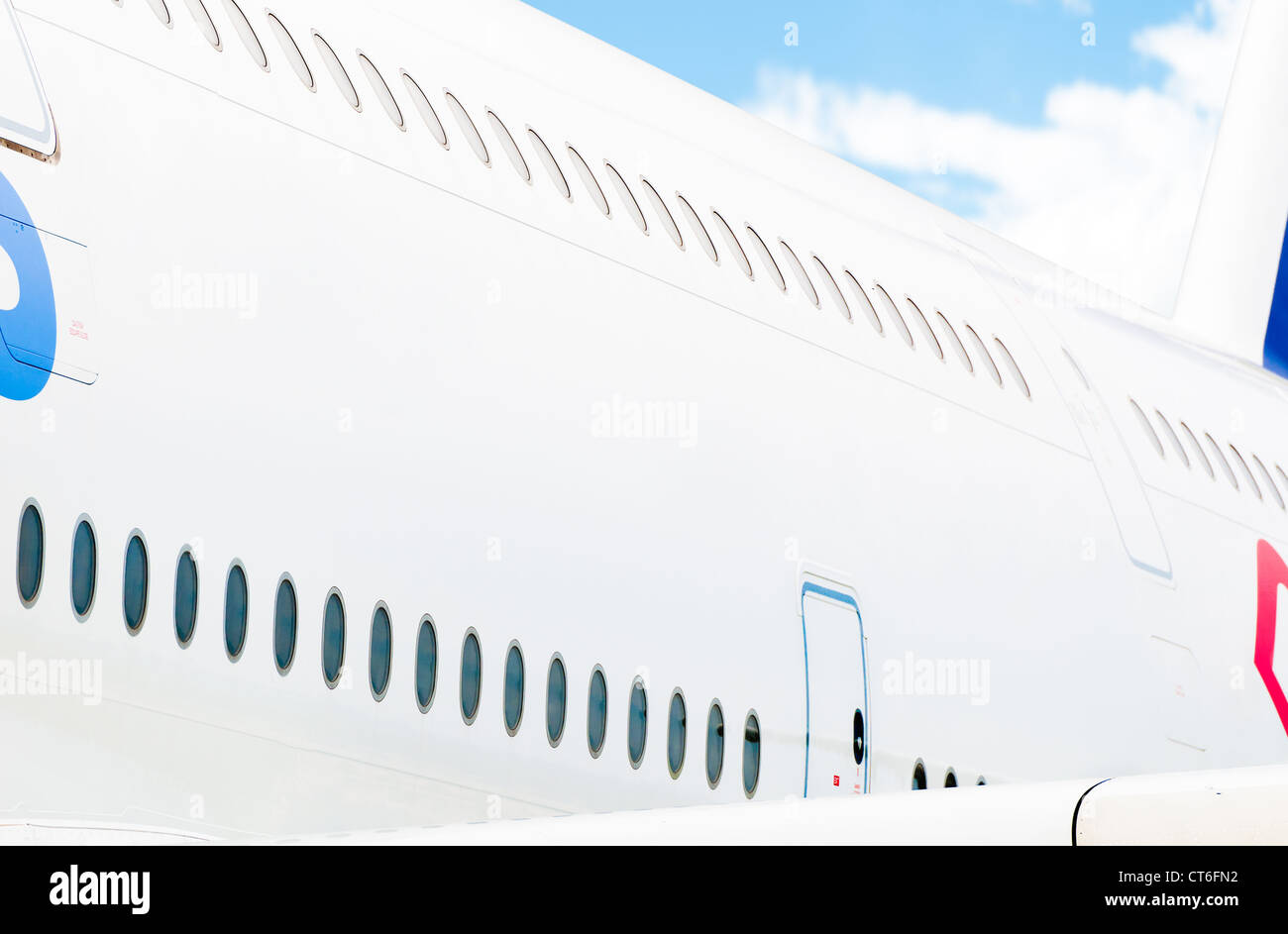 Side view of white passenger plane with two rows of windows and blue ...