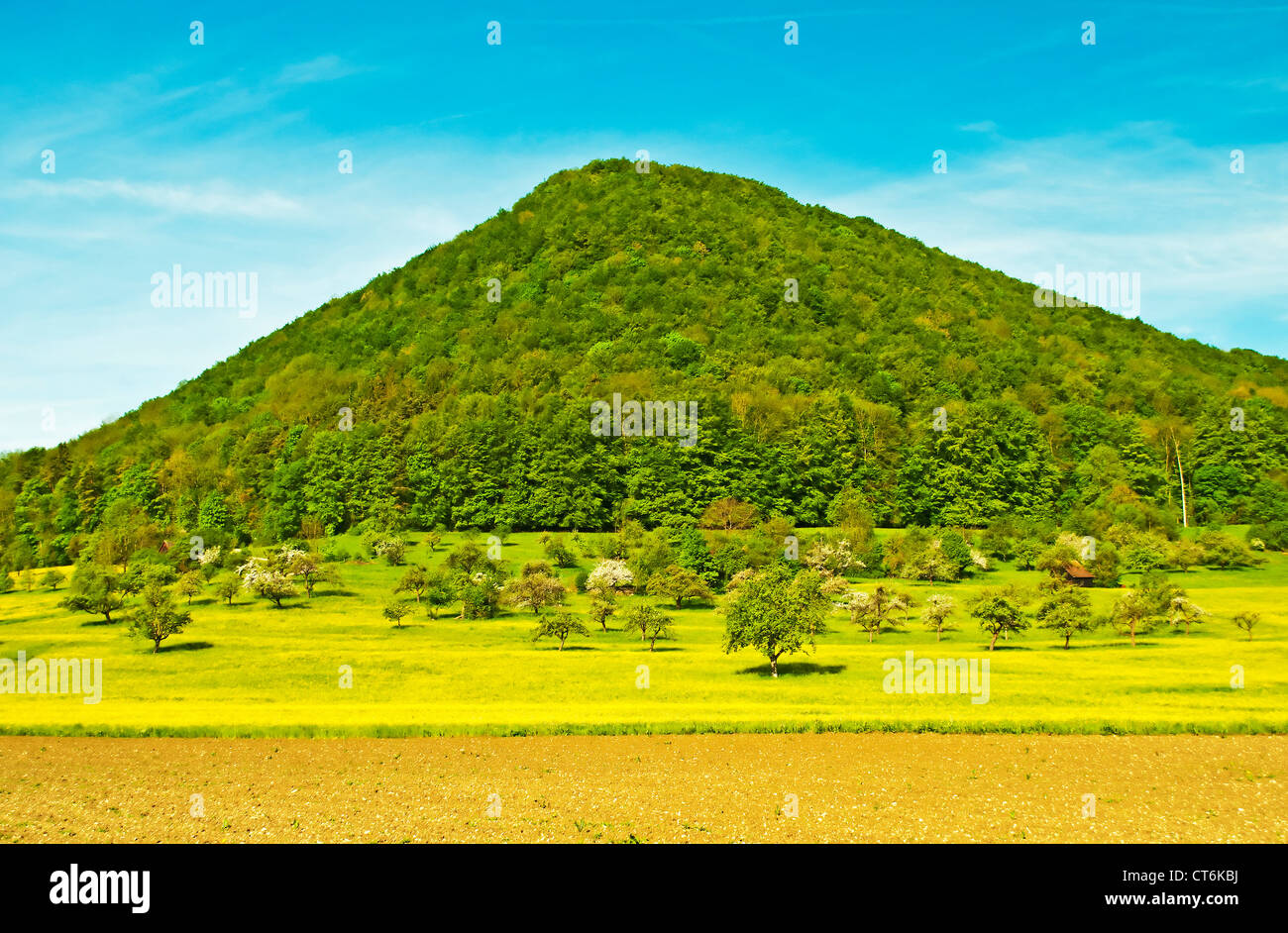 landscape in spring with a hill and blue sky Stock Photo - Alamy