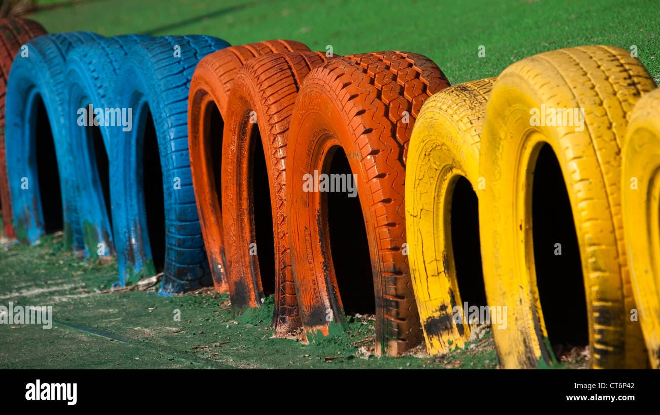 Group of multicoloured painted tyres in playground Stock Photo - Alamy