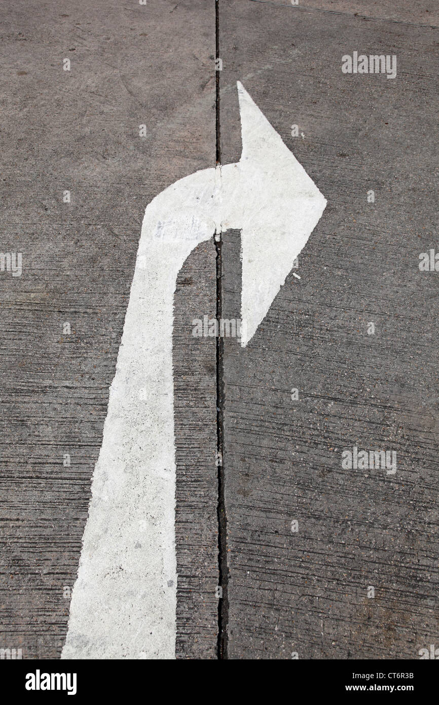 it's a photo of a painted arrow on the road to indicate the direction ...