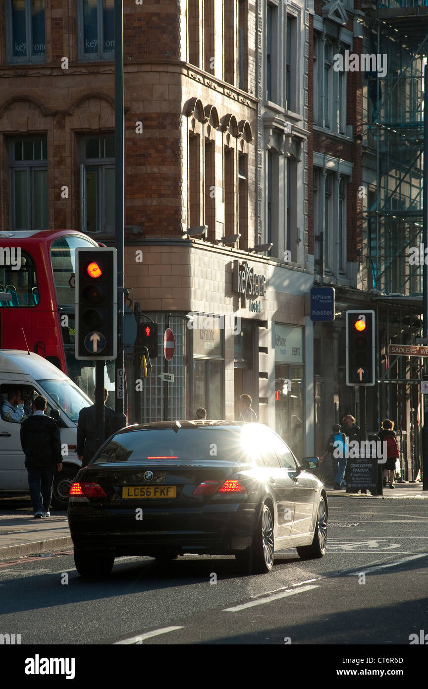 Traffic waiting at red traffic lights on a busy London street early in ...