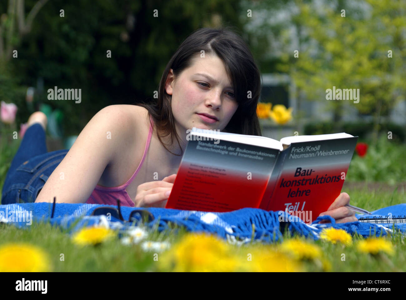 Attractive student reading a textbook Stock Photo - Alamy