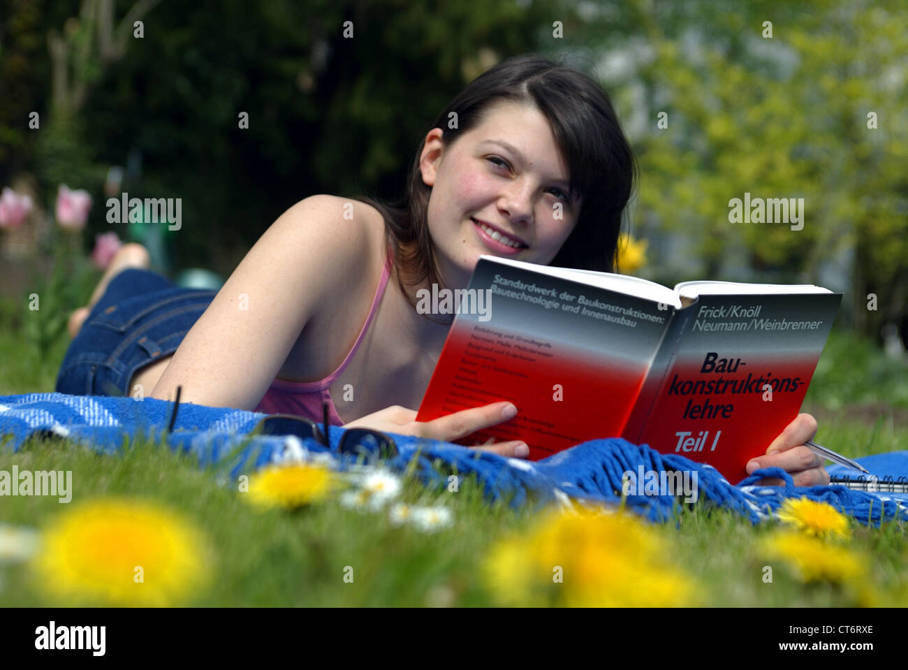 Attractive student reading a textbook Stock Photo - Alamy