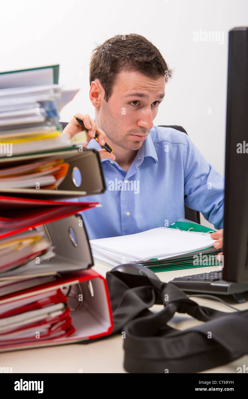 Confused accountant looking at some info on the display of his computer ...