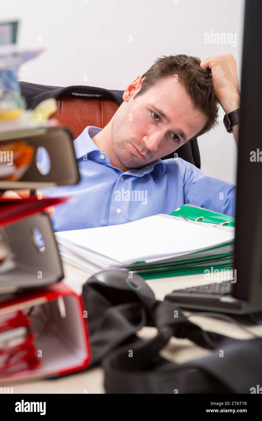 Office businessman at his desk full of documents, showing an ...