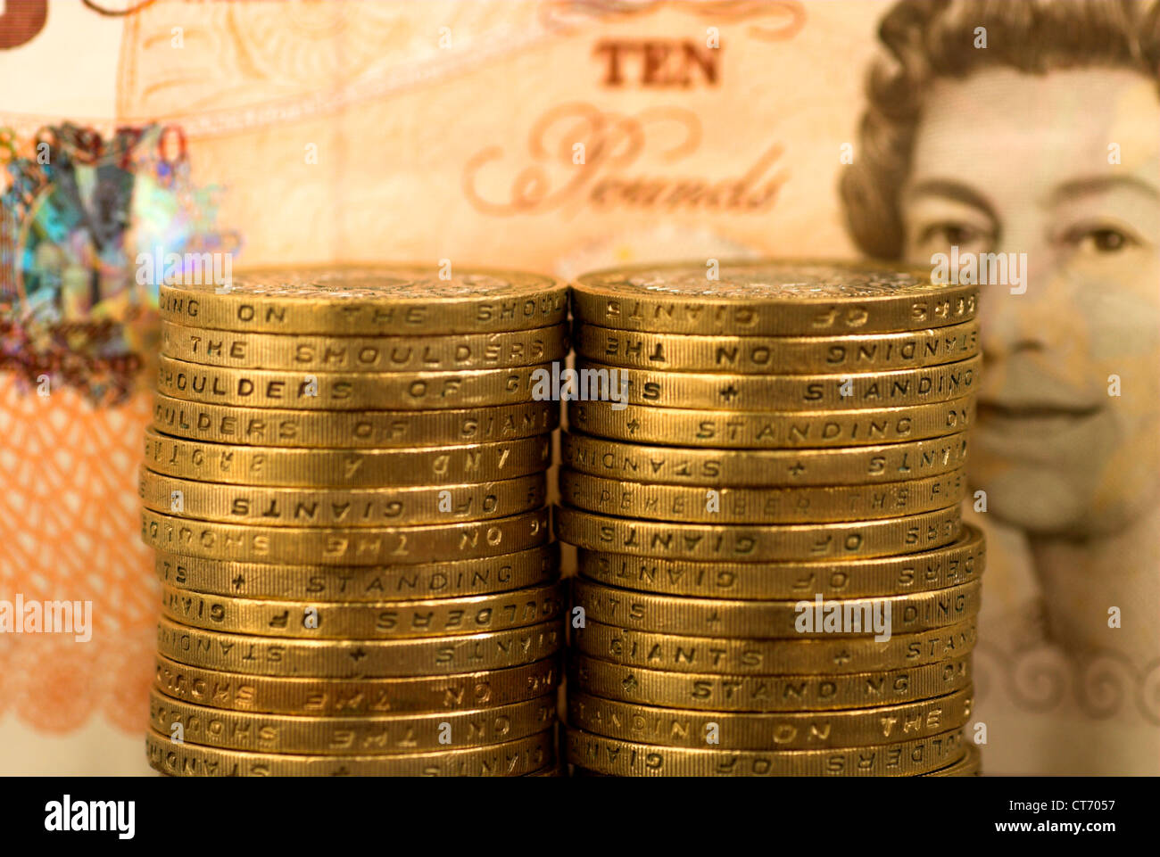Two pounds coins stacked with a ten pound note in the background Stock ...