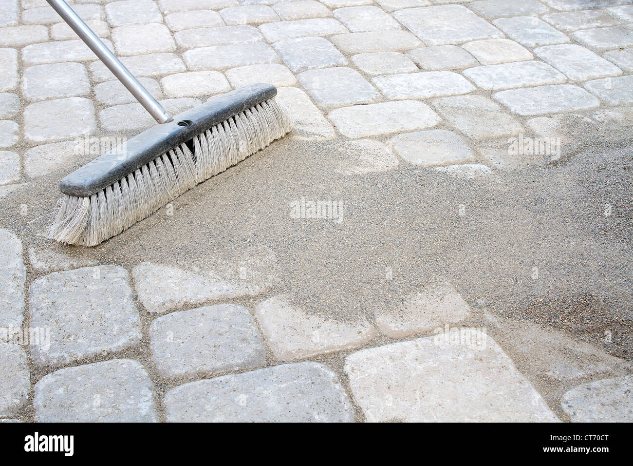 Broom Sweeping Locking Sand Into Backyard Patio Pavers Stock Photo - Alamy