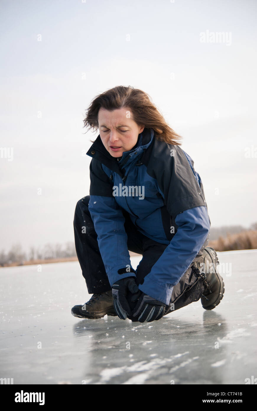 Young woman with knee injury on frozen icy lake Stock Photo - Alamy