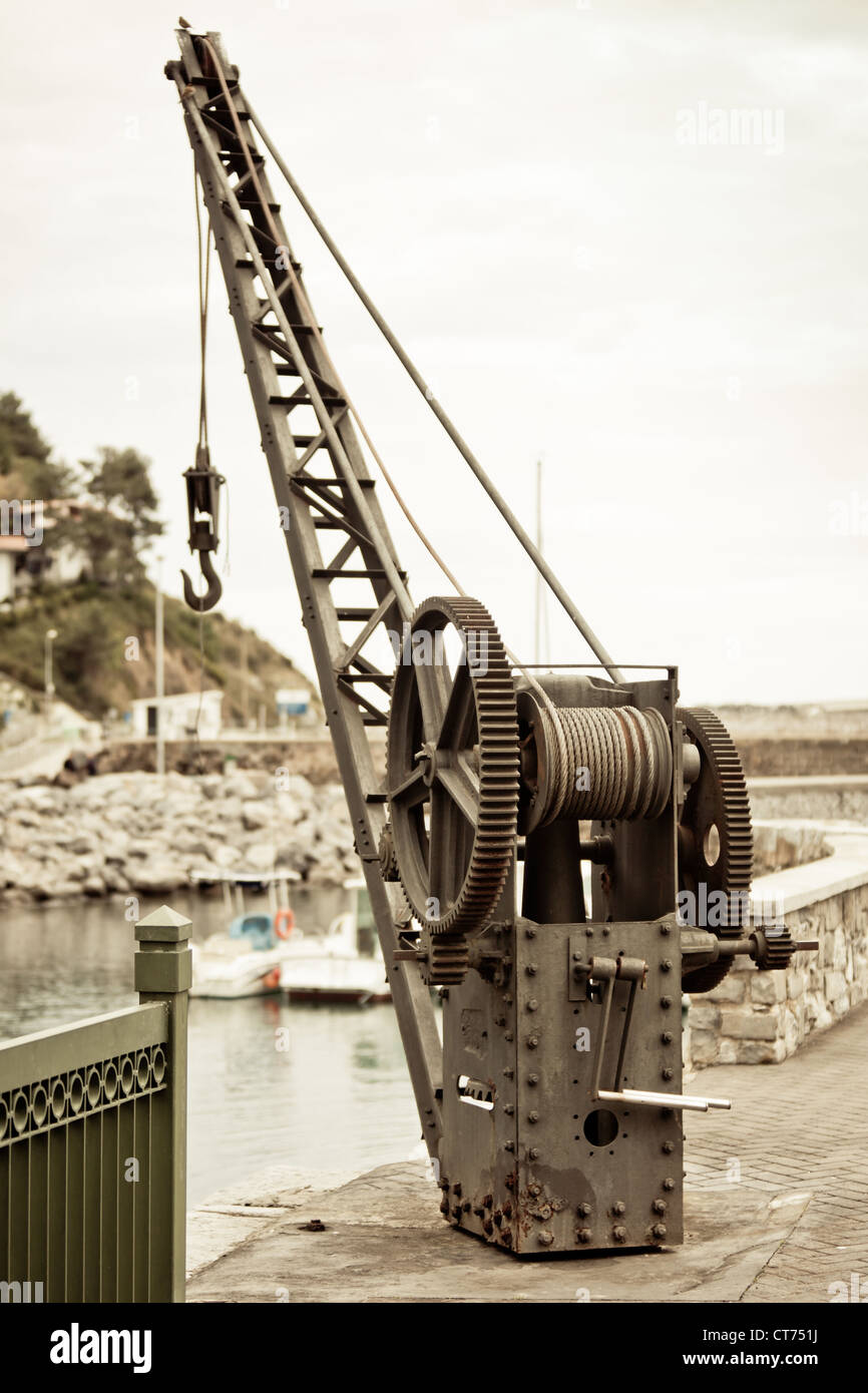 Old fishing crane in small seaside town harbor. Toned image Stock Photo ...