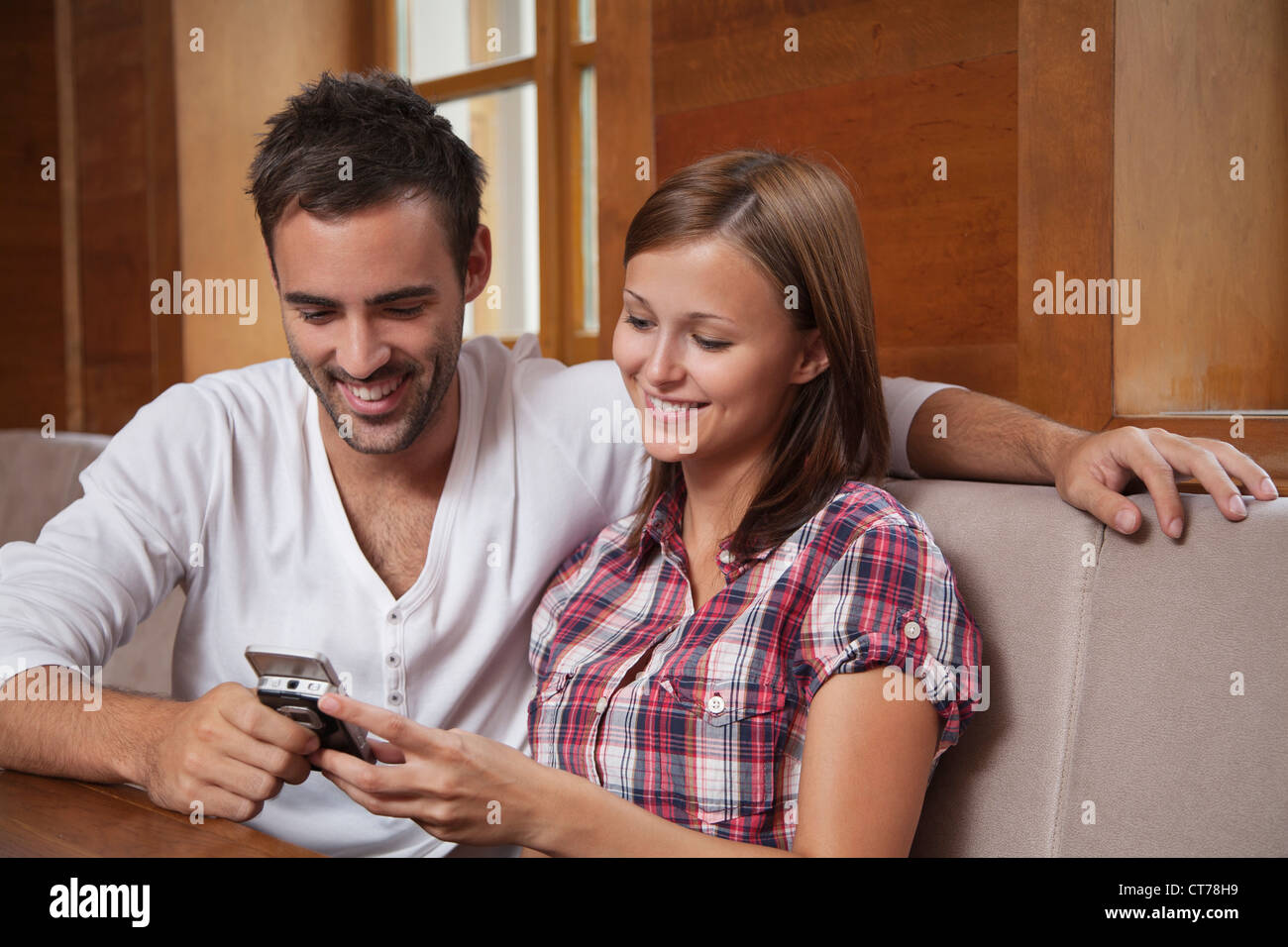 young couple sharing text message on mobile phone Stock Photo - Alamy