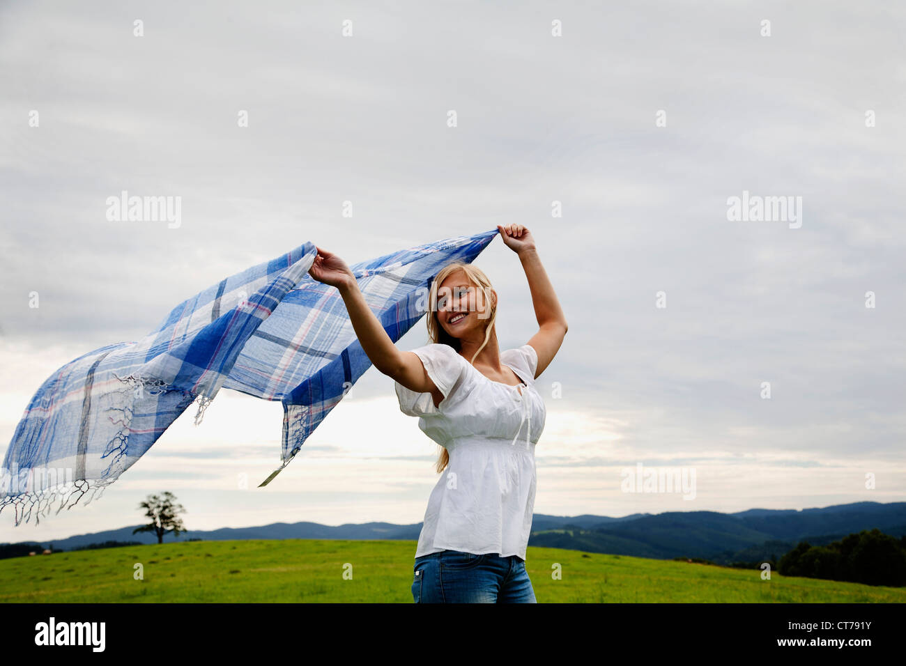 young woman waving cloth through the air Stock Photo - Alamy