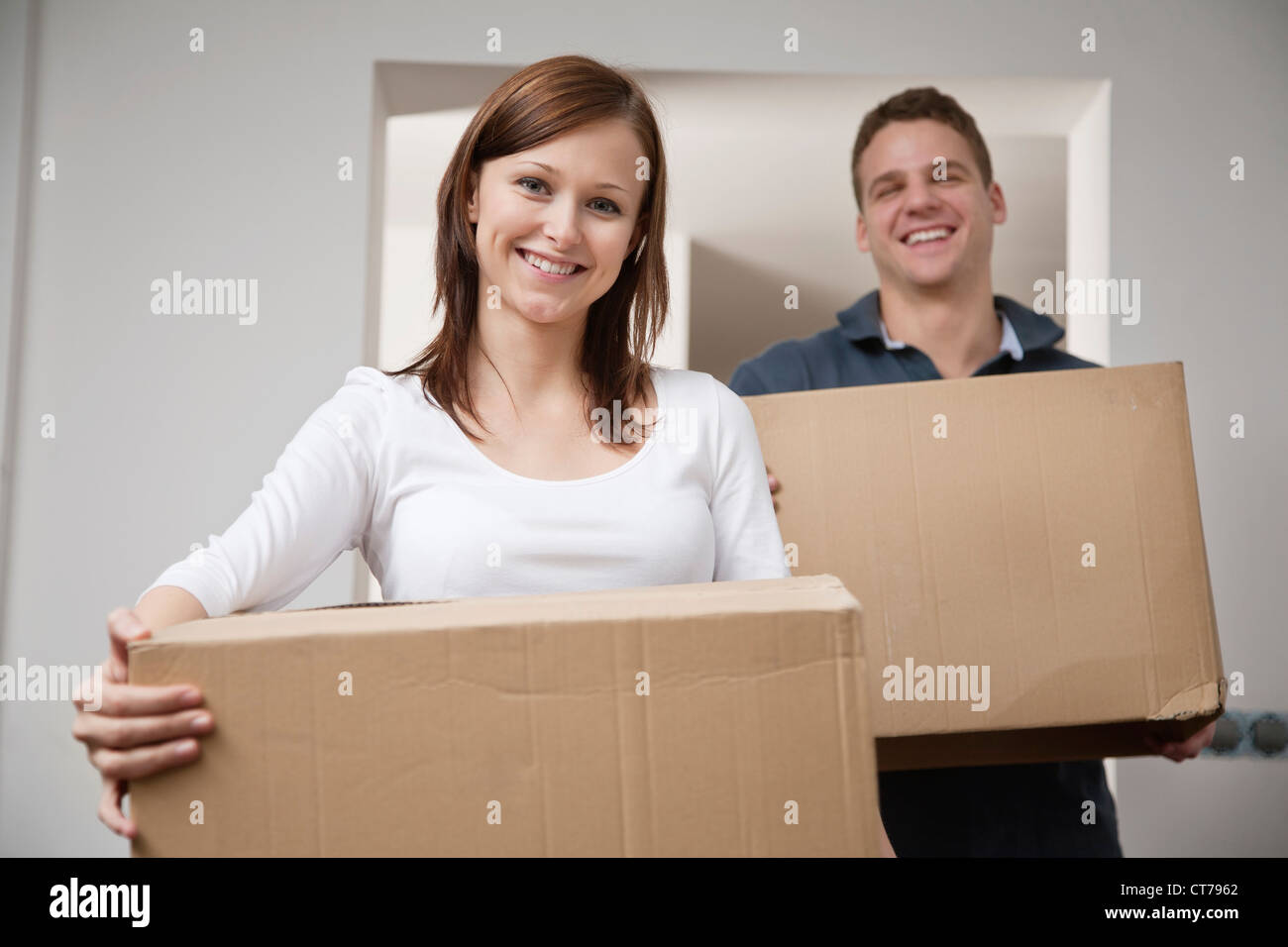 young couple carrying moving boxes Stock Photo - Alamy