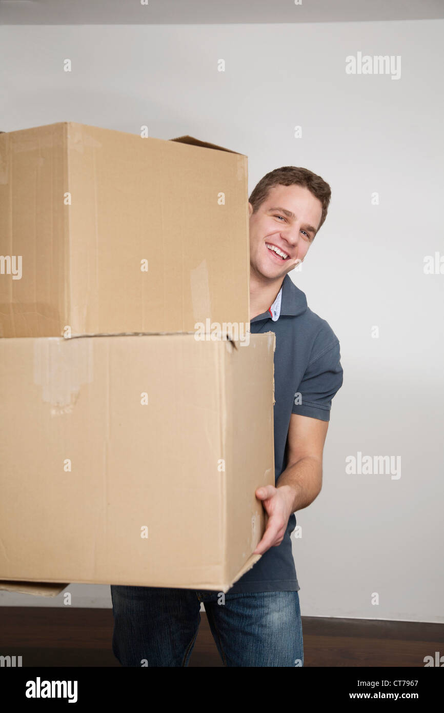 portrait of young man carrying moving boxes Stock Photo - Alamy