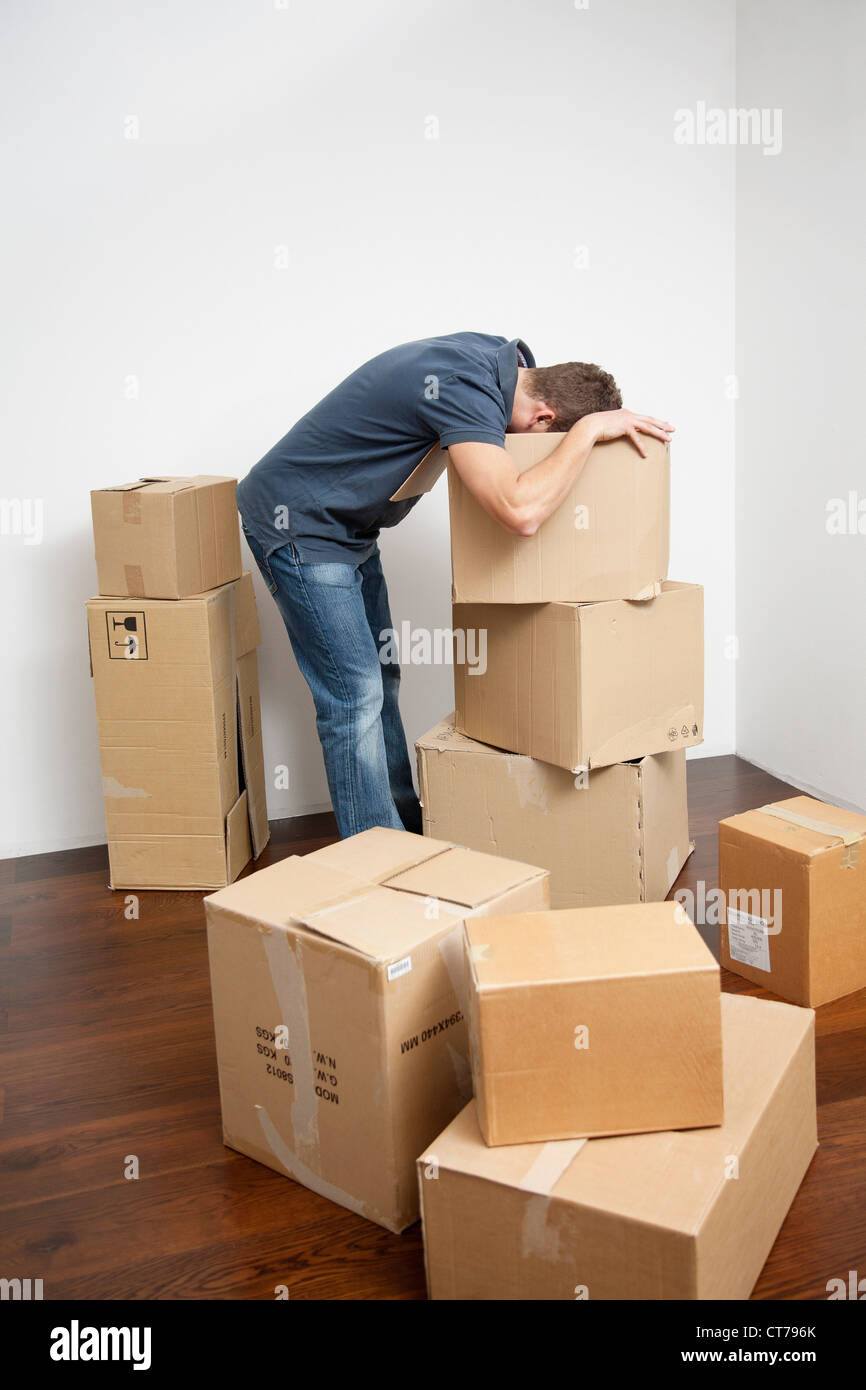 young man searching for something in moving boxes Stock Photo - Alamy