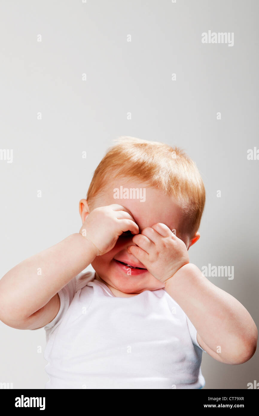 Baby boy rubbing eyes Stock Photo - Alamy