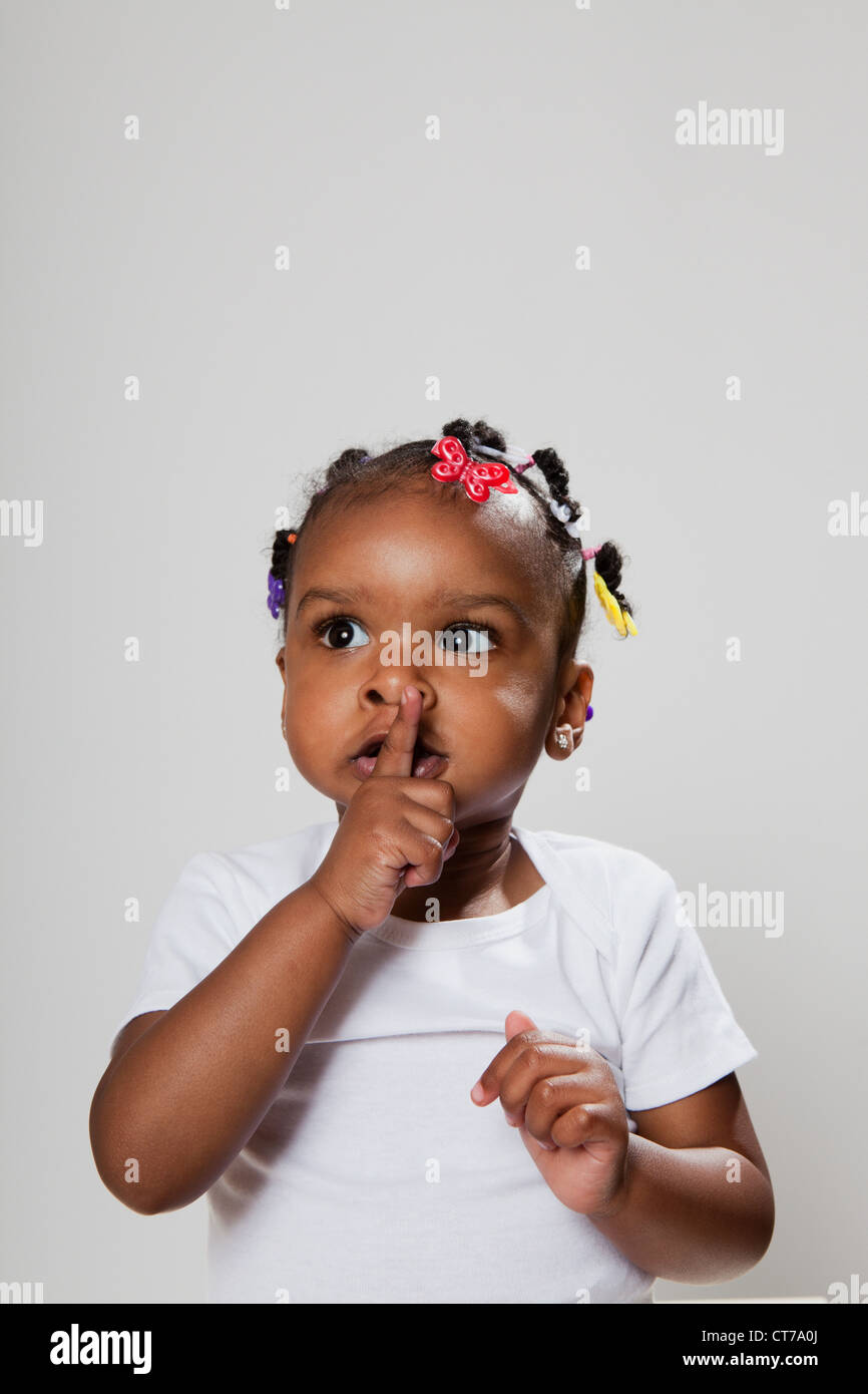 Girl with finger on lips Stock Photo - Alamy