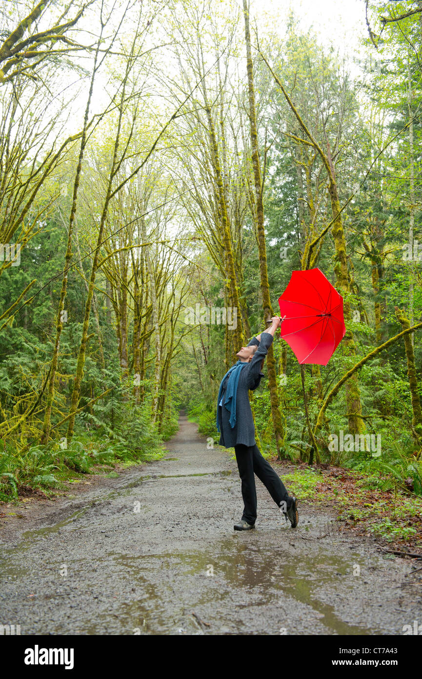 Woman on forest path with red umbrella Stock Photo - Alamy