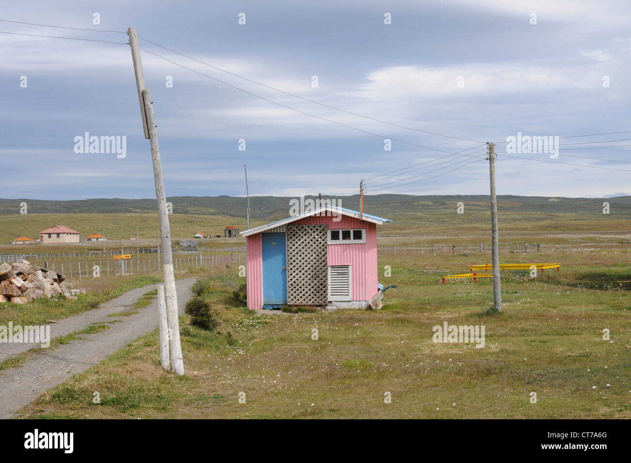 Pink hut with blue door, telegraph poles, wide empty landscape ...