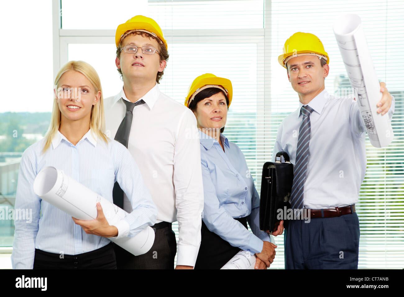 Group of architects in helmets interacting in office Stock Photo - Alamy