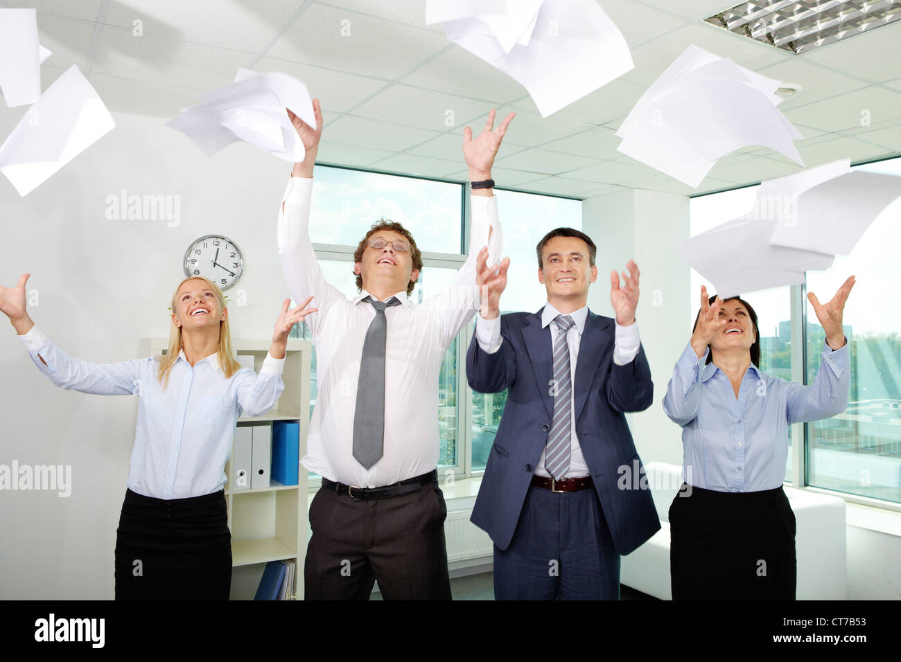 Group of excited businesspeople throwing papers in office Stock Photo ...