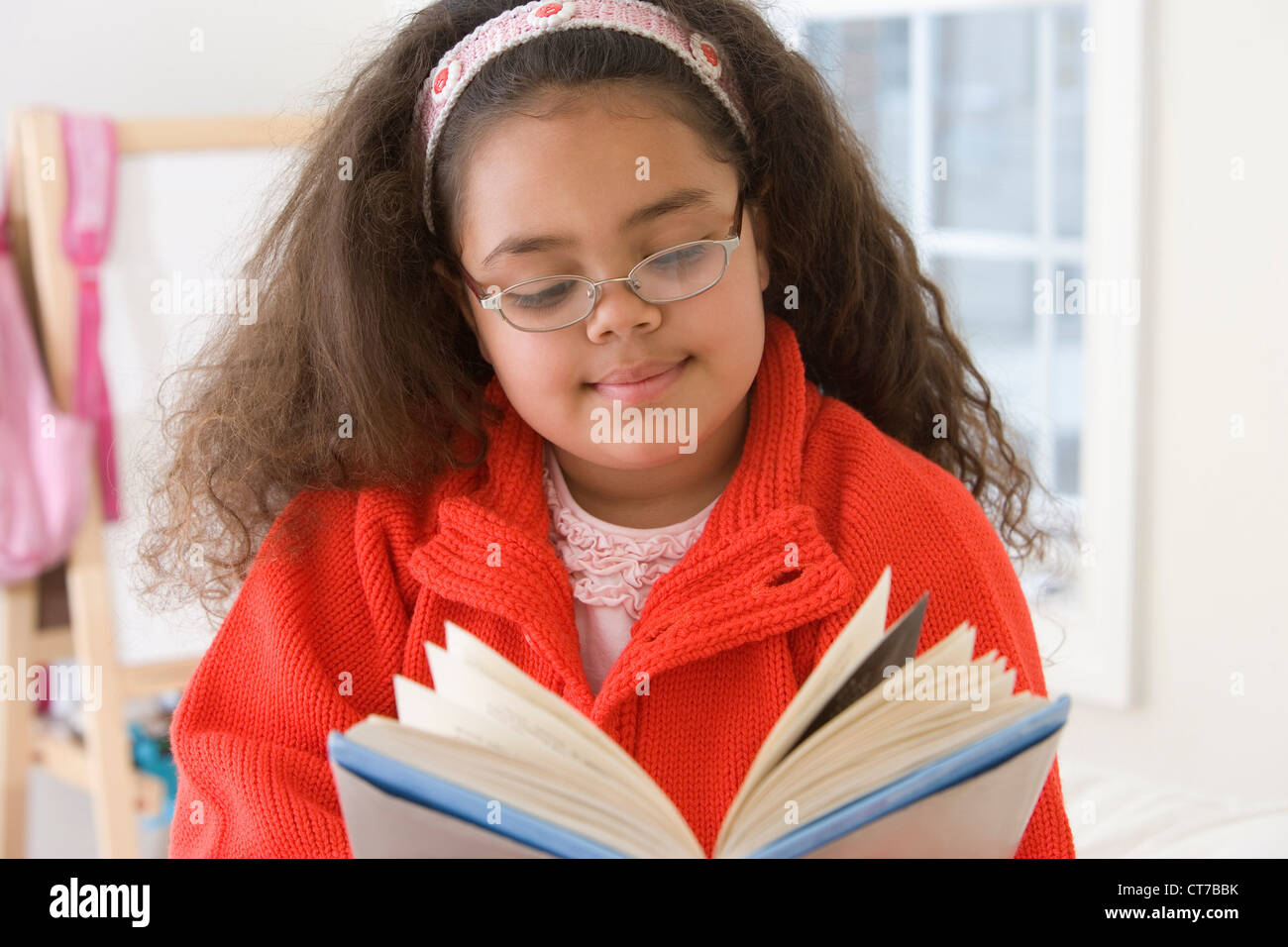 Girl reading a book at school Stock Photo - Alamy